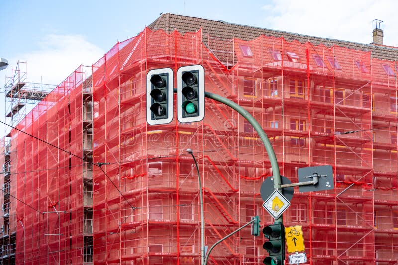 A Red Building with Scaffolding and a Green Traffic Light Stock Photo ...