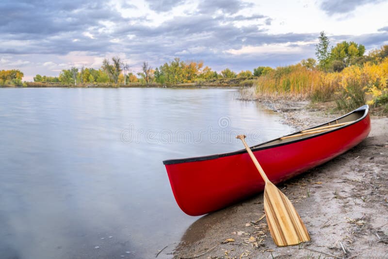 Red canoe on a lake shore stock photo. Image of canoe - 128256040
