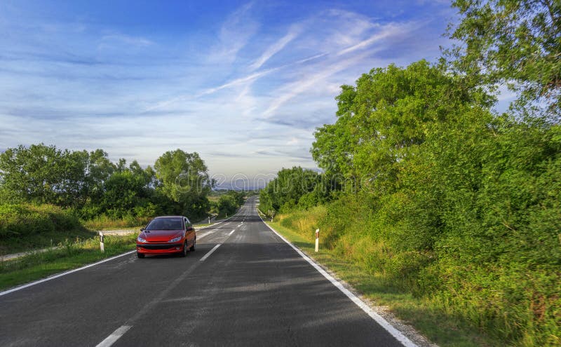 A Red Car Drives Down a Quiet Rural Highway Stock Image - Image of ...