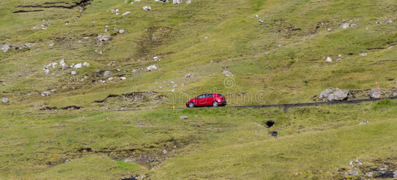A Red Car Runs through the Desolate Hills of the Faroe Islands Stock ...