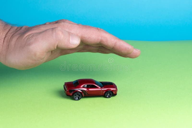 Red Car Toy Covered by Hand. Car Insurance Concept Stock Photo - Image ...