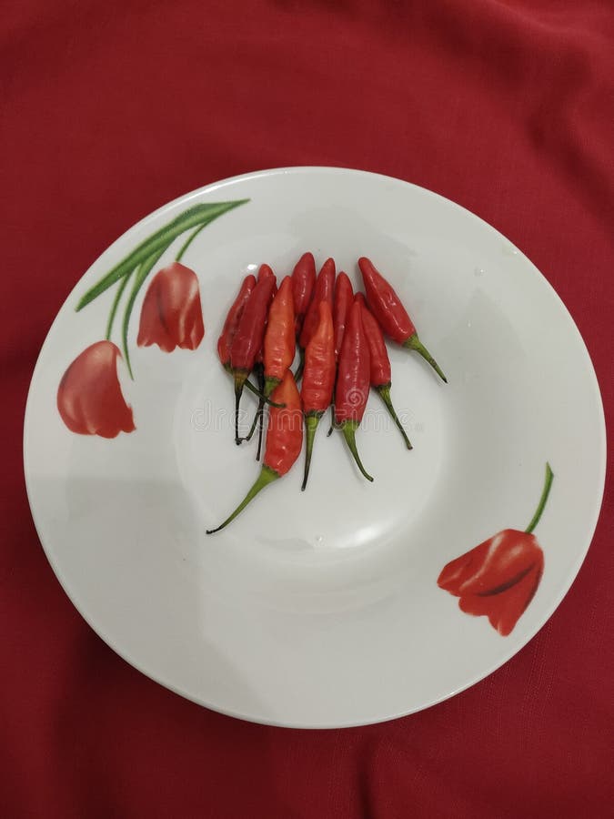 Red Cayenne Pepper in a Ceramic Plate with Red Flower Motifs Stock ...