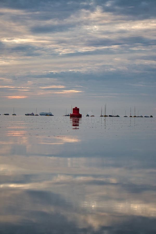 Red Channel Marker Sticking Out of a Tranquil Sea with the Reflection ...