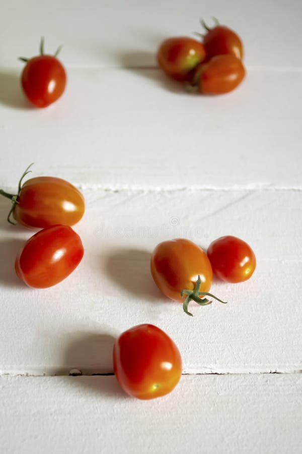Red Cherry Tomatoes on a White Table. Cherry Tomato - a Few Pieces are ...