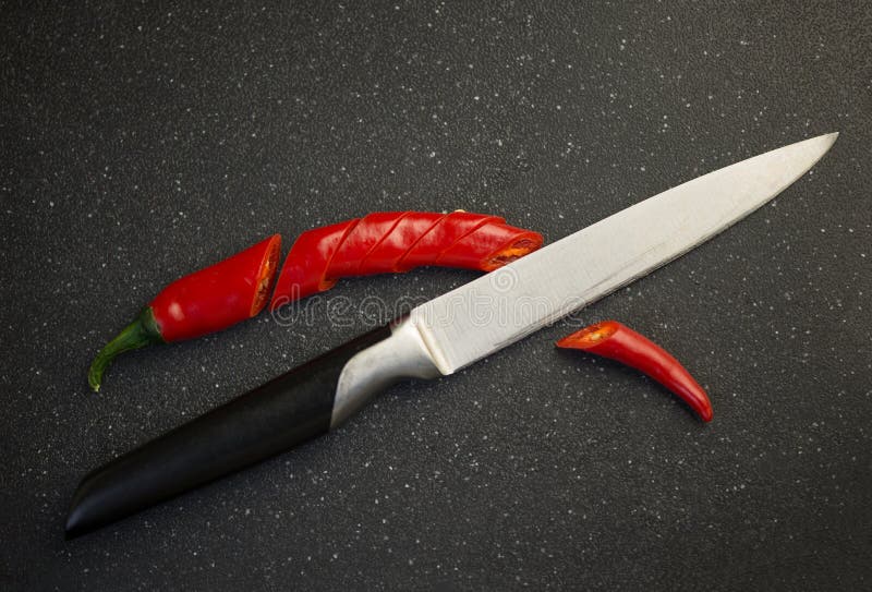 Red Chili Pepper Cut into Pieces on a Black Background. Hot Spice, Red ...