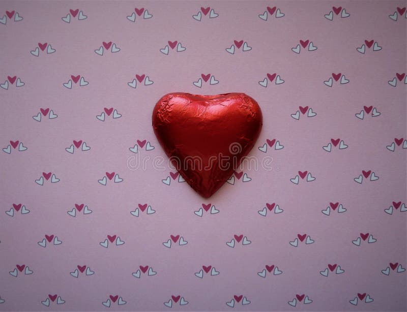 Red Foil Wrapped Heart on Pink Hearts Background Stock Image - Image of ...