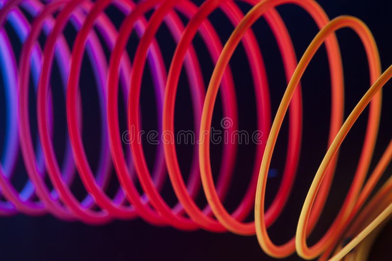 Red Circular Objects are Lit with Fluorescent Colors Against a Deep ...
