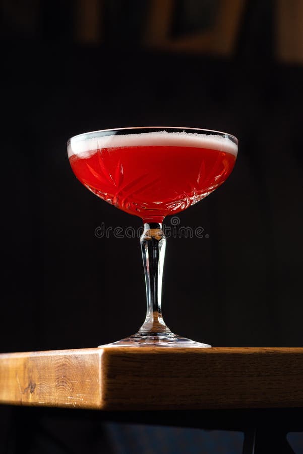 Red Cocktail in Coupe Glass with Layer of Foam on Black Background ...