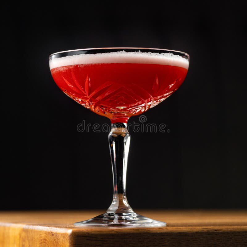 Red Cocktail in Coupe Glass with Layer of Foam on Black Background ...