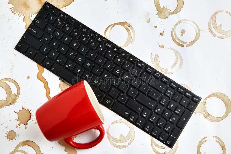 Red Coffee Cup Overturned on a Computer Keyboard on a Table with Coffee ...