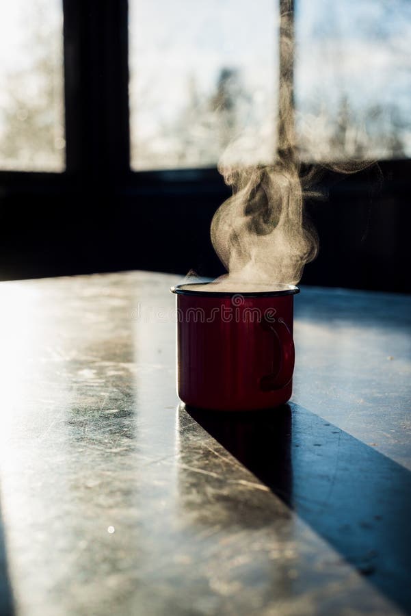 A Red Coffee Mug Sits on the Table, Steaming Stock Photo - Image of ...