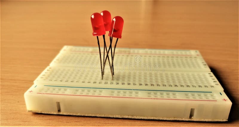 Red Colored LED Lights on a Breadboard for Conducting Electronics ...