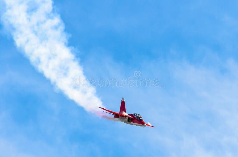 Red Combat Fighter with White Smoke Behind in the Blue Sky Stock Photo ...