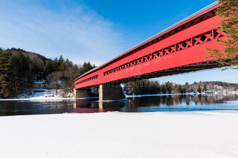 The Red Covered Bridge on the Frozen River Stock Photo - Image of ...