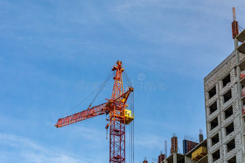 Red Crane at a Construction Site Against a Blue Sky. Construction of a ...