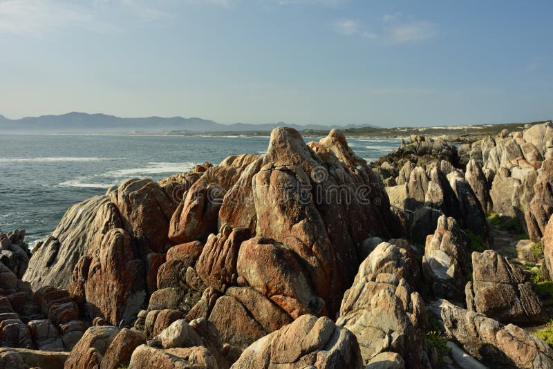 Red and Cream Colored Seaside Rocks Looking Like Sculptures Stock Image ...