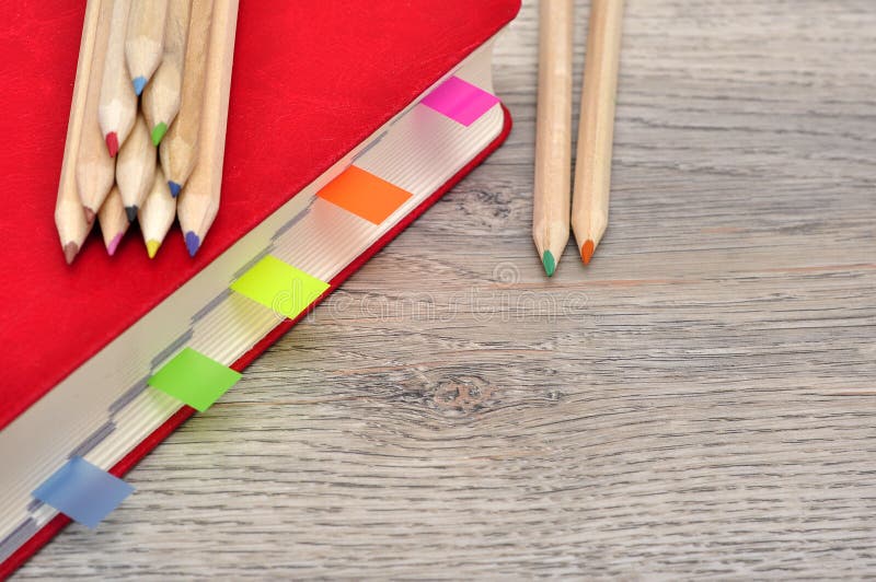 Red Diary Notebook and Colored Pencils on the Desk Wood Texture. Stock ...