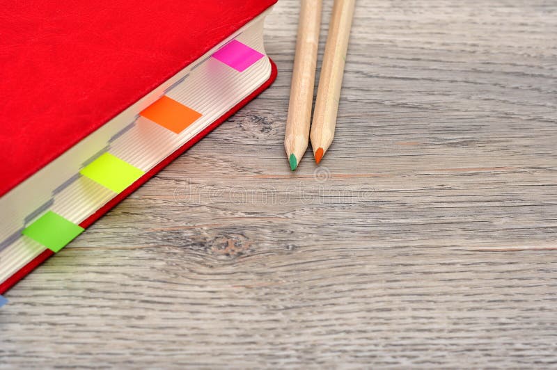Red Diary Notebook and Colored Pencils on the Desk Wood Texture. Stock ...