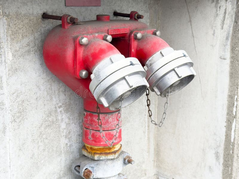 Red Double Fire Hydrant Pipe with Chains on Concrete Wall Stock Image ...