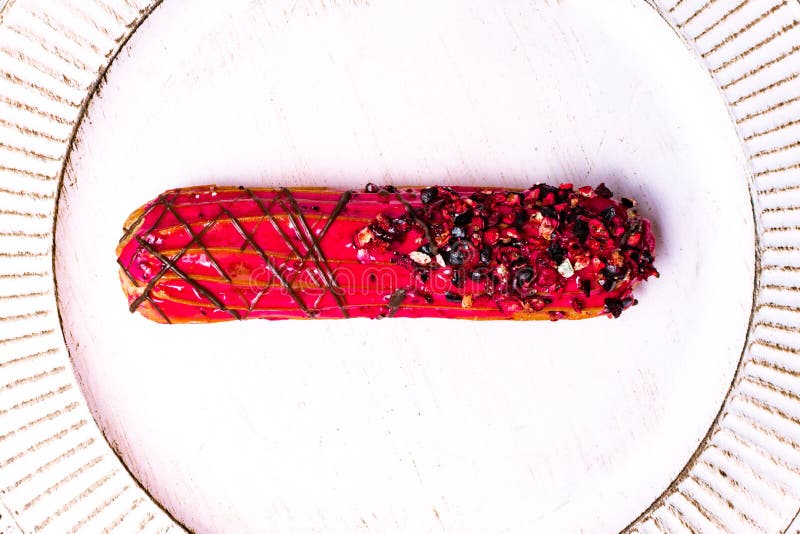 Red Eclair Decorated with Chocolate on White Background. Rustic Style ...