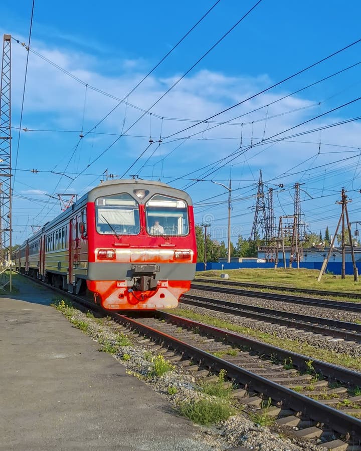 Red Electric Train Rides on Rails by the Station in Summer Stock Image ...