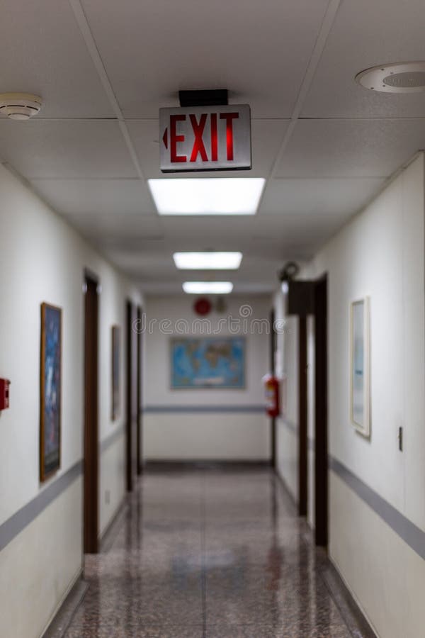 Red Emergency Exit Sign in the Dark Room. Illuminated Office Exit Sign ...