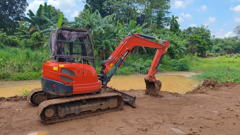 A Red Excavator Stands on Wet Ground. Stock Photo - Image of lake ...