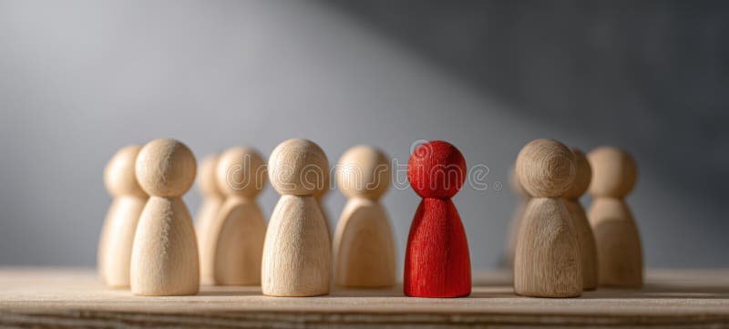 The Red Figure Standing Out among a Group of Wooden People in a Studio ...