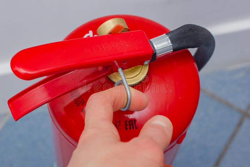 Red Fire Extinguisher on the Floor, Hand Shows How To Pull the Check ...