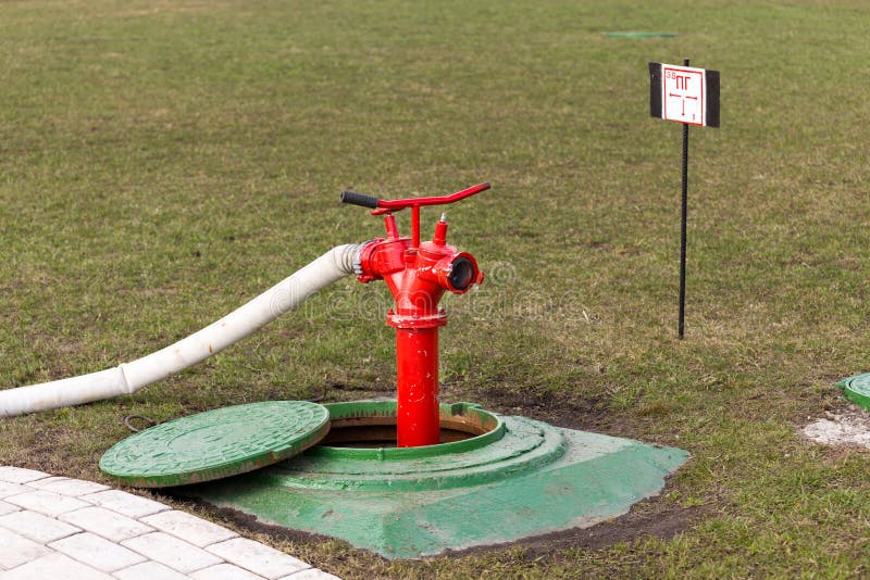 Red Fire Hydrant Stands in Manhole Stock Photo - Image of water ...