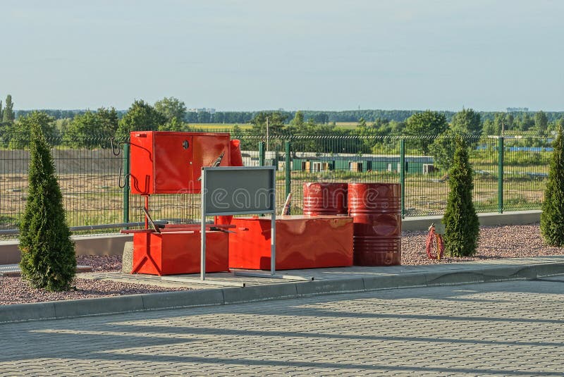 A Red Fire Shield with Two Iron Barrels Stands on a Gray Sidewalk Stock ...