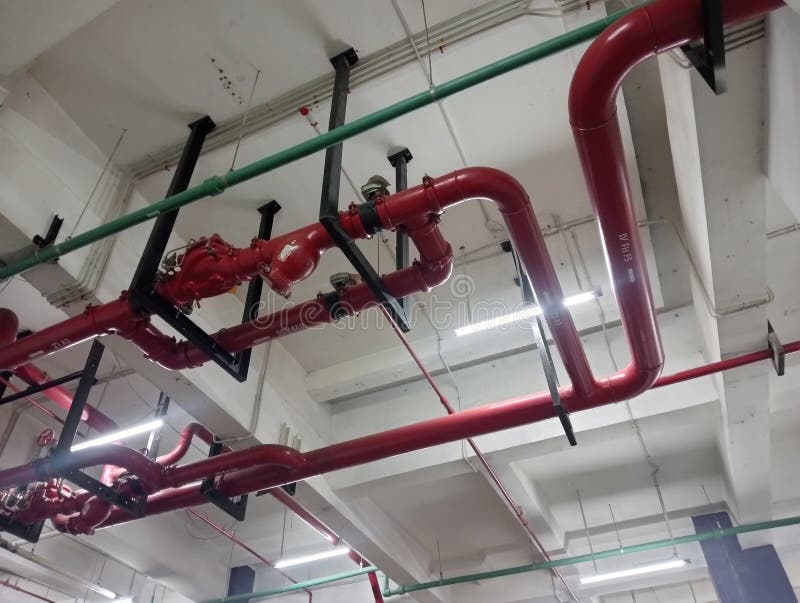 Red Fire Sprinkler System Pipes and Valves Installed Under Ceiling Structure for Building Safety ...