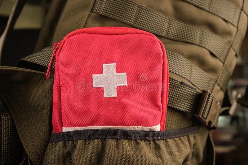 A Red First Aid Kit with a White Cross in the Pocket of a Tactical ...