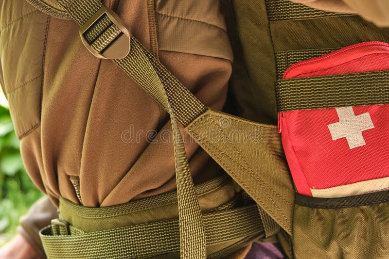 A Red First Aid Kit with a White Cross in the Pocket of a Tactical ...