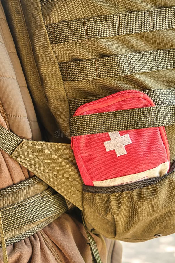 A Red First Aid Kit with a White Cross in the Pocket of a Tactical ...