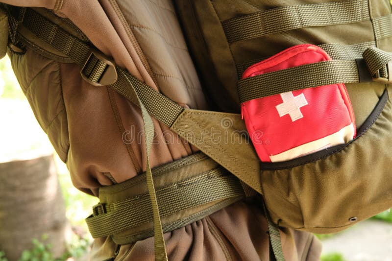 A Red First Aid Kit with a White Cross in the Pocket of a Tactical ...