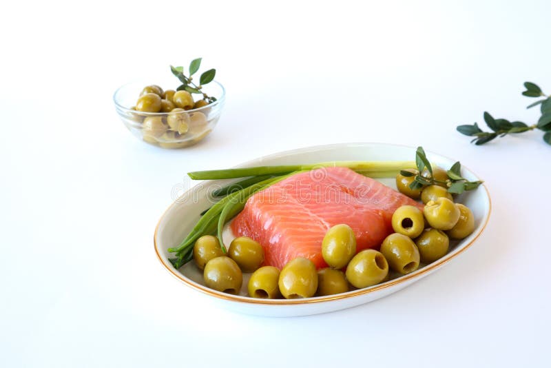 Red Fish with Olives, Green Onions on a Platter on the Background of a ...