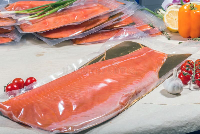 Red Fish in a Sealed Vacuum Plastic Bag on the Background of a Stack of ...