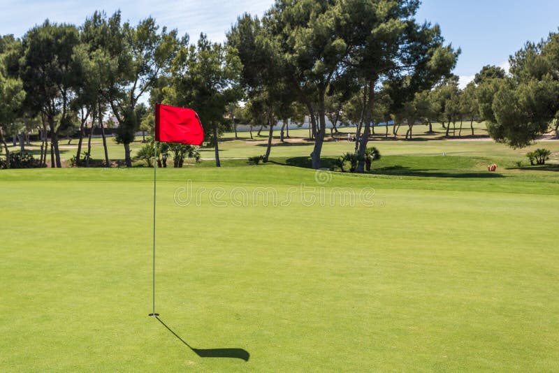 Red Flag in the Hole on a Green Golf Field Stock Photo - Image of ...