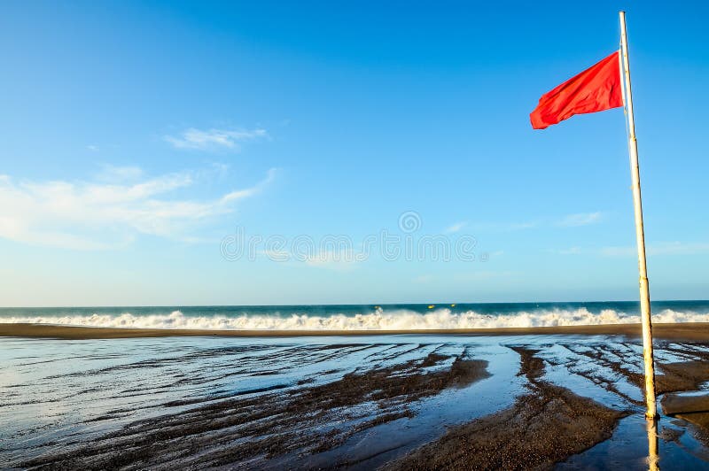 A Red Flag is on a Pole on a Beach Stock Photo - Image of clouds, blue ...