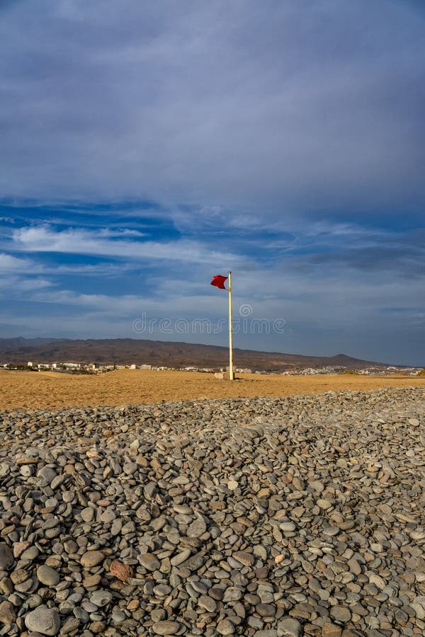 A Red Flag is on a Pole in a Field of Rocks Stock Image - Image of flag ...