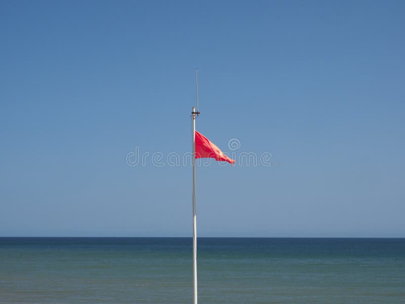 Red flag at sea stock photo. Image of space, water, high - 313939572