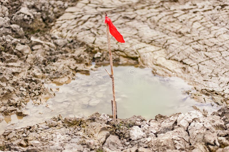 Red Flag on a Stick in Puddle Stock Photo - Image of dirt, flag: 123051844