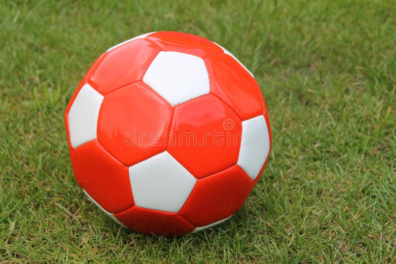 A Red Football in the Grass Stock Photo - Image of colored, lawn: 26424748