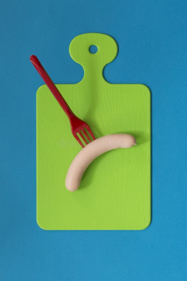 Red Fork and Sausage on a Kitchen Board on a Blue Stock Image - Image ...