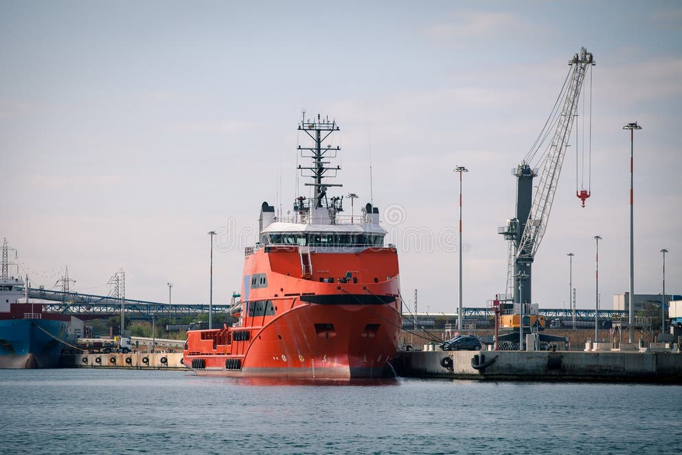 Red Freight Ship in Front of Port Facilities and Cranes Stock Image ...