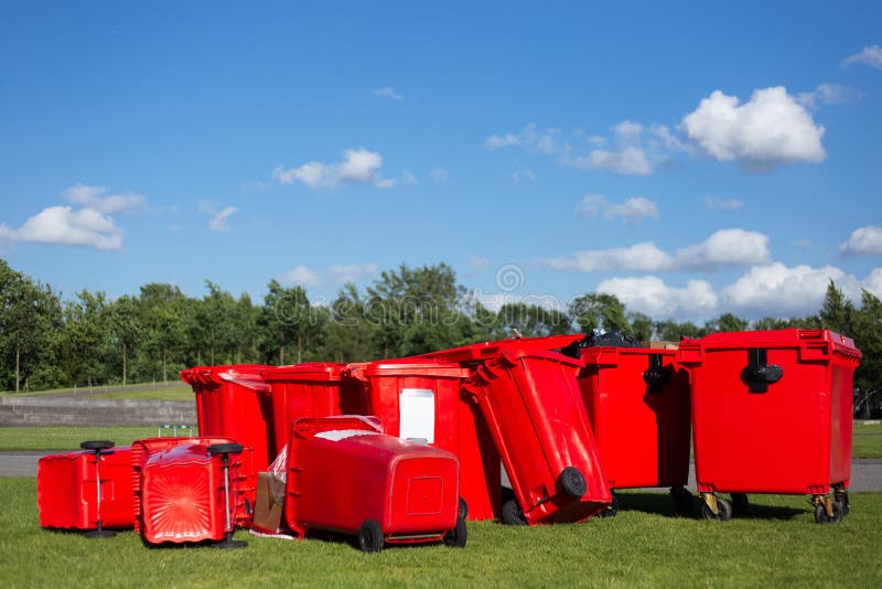 Red Garbage Containers on the Green Grass in Park on Background of Blue ...