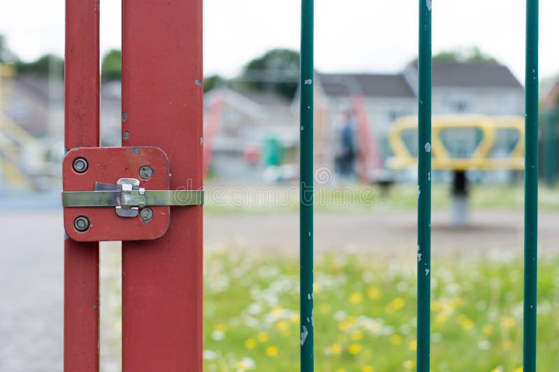 Red Gate Locked with Playground in the Background Stock Image - Image ...