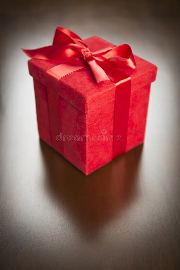 Red Gift Box with Ribbon and Bow Resting on Wood Stock Image - Image of ...