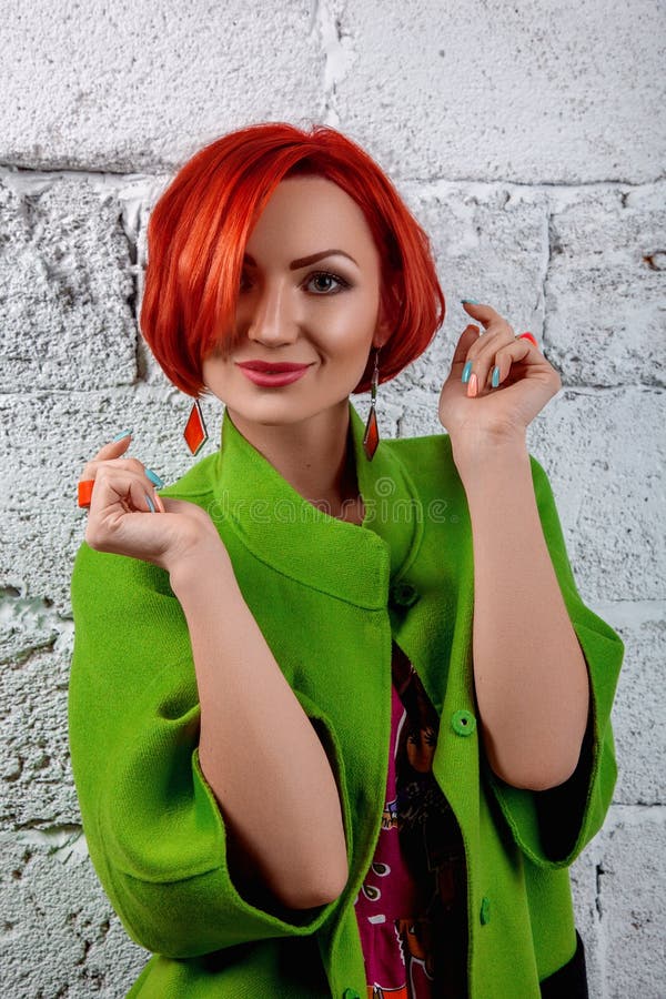 The Red Girl in a Green Jacket at a Wall Brick 1. Stock Photo - Image ...